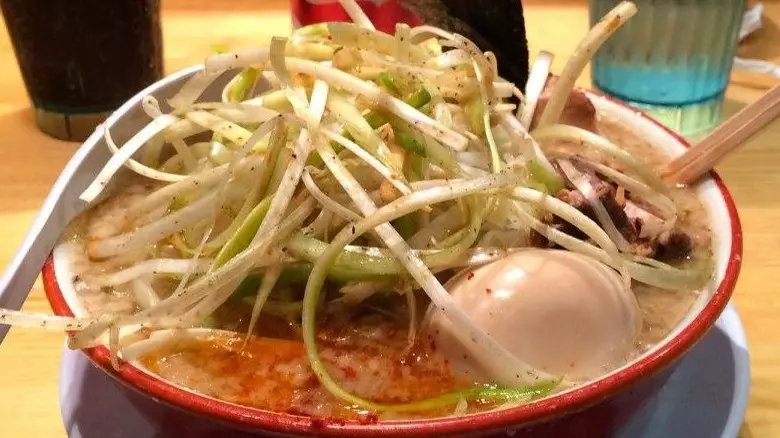 Frijoles, fideos y huevo en tazón rojo.