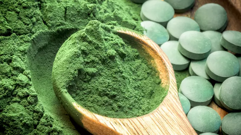 Spirulina bubuk ing sendok lan tablet