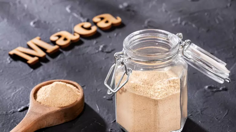 Un bote de maca con maca deletreado en letras de madeira