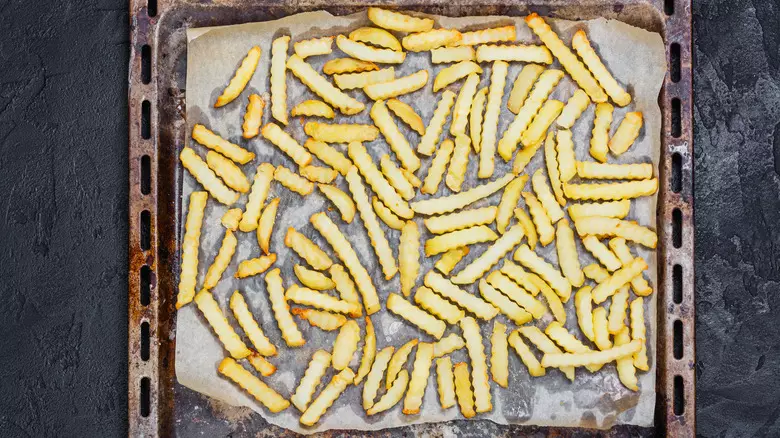 crinkle cut fries on parchment lined baking sheet