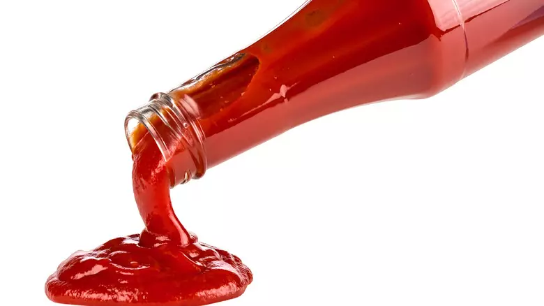 Ketchup ပုလင်းကို နှုတ်ခမ်းစူပြီး ketchup ကိုထုတ်သည်။