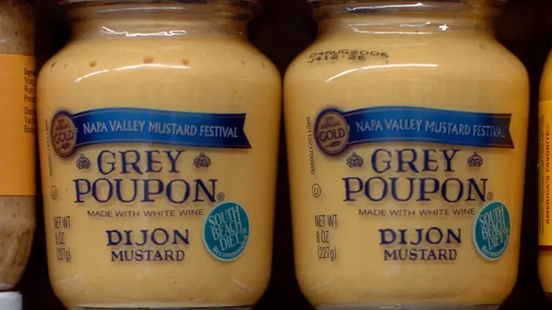 Крупним планом банки сірої гірчиці Poupon