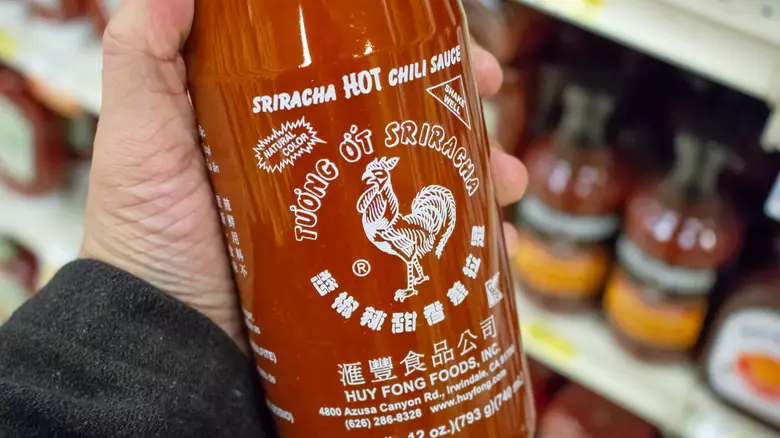 Əlində Huy Fong Sriracha sousu olan şəxs