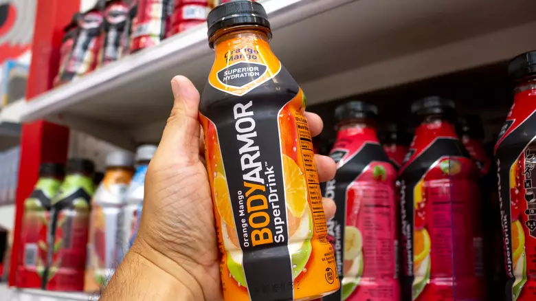 Apelsin Mango Bodyarmor ichimligini ushlab turgan qo‘l