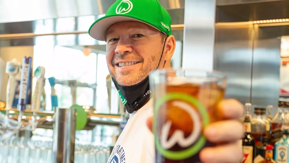 Wahlburgers Donnie Wahlberg drží sklenici na pití směrem k fotoaparátu