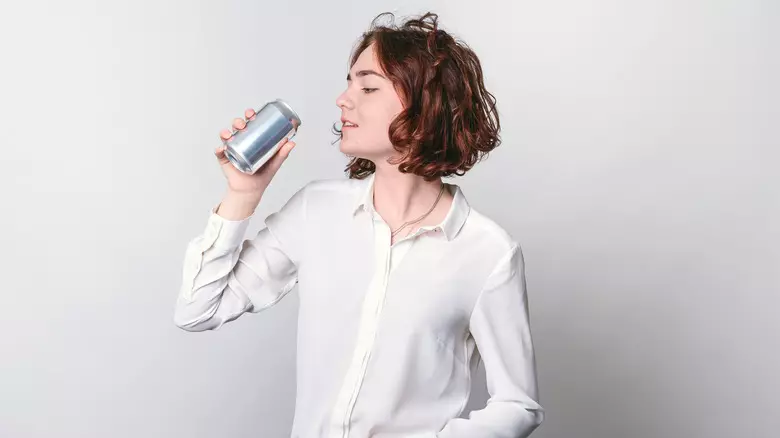 vrouw drinkt uit blikje frisdrank