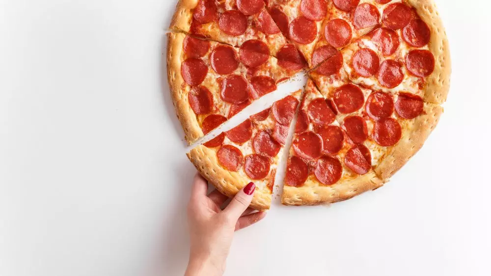 ມືເອົາ pizza pepperoni ເປັນຕ່ອນ