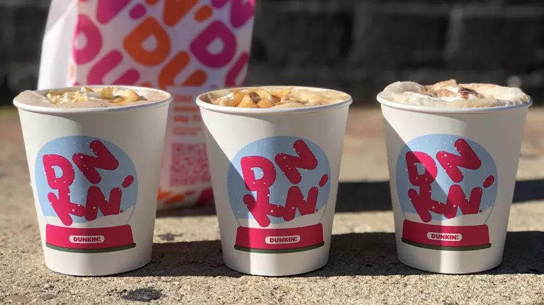 Tres cuncas de café dunkin donuts vacacións 2021 diante dunha bolsa dunkin donuts