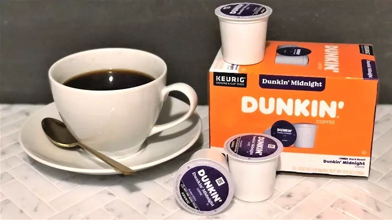 unha cunca de café sentada xunto ás rosquillas Dunkin Dunkin' a media noite caixa de k-cups café