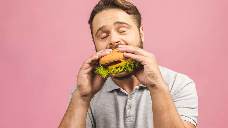 Hombre comiendo una hamburguesa