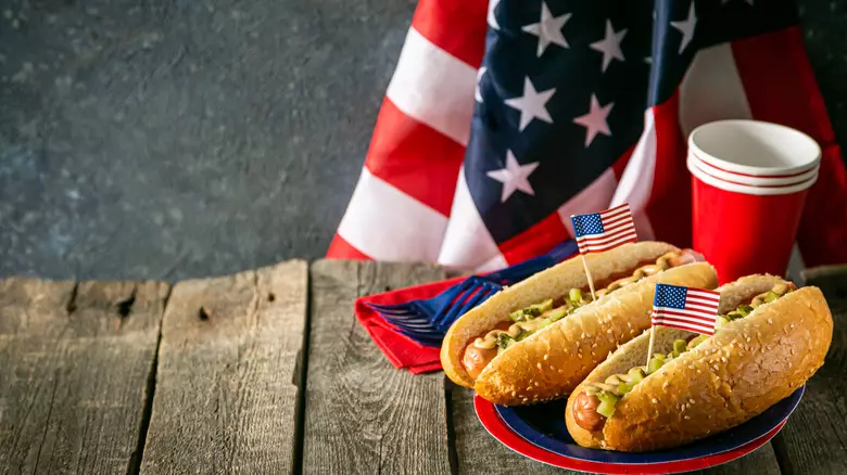 Bi hot dog paperezko edalontziekin eta bandera amerikar batekin