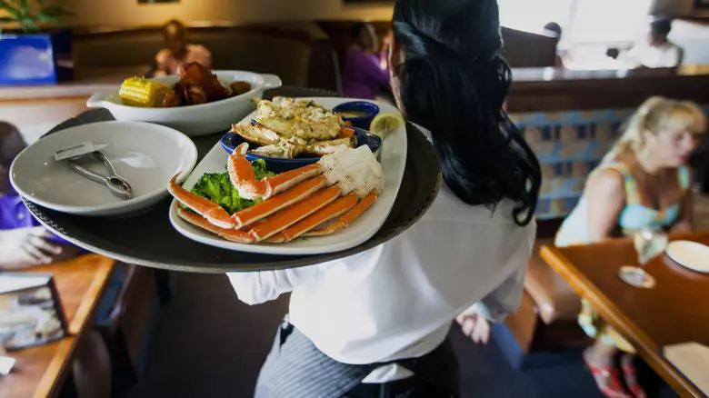 Þjónustustúlka ber bakka í gegnum Red Lobster