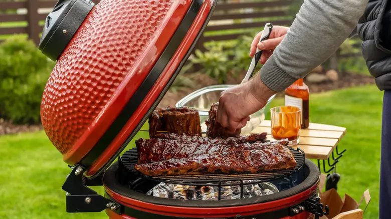 Comida cocinando dentro de una parrilla de cerámica roja