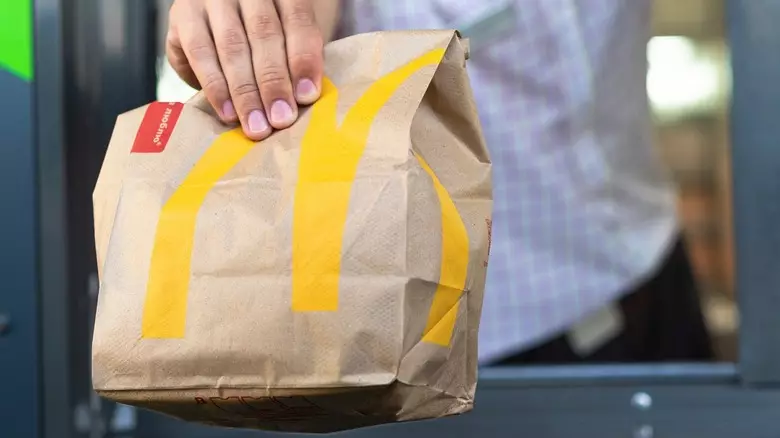 Employé du service au volant de McDonald's donnant la commande