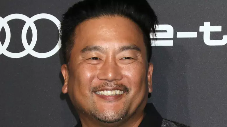 Roy Choi tersenyum di karpet merah