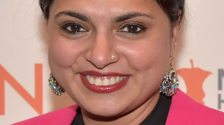 Maneet Chauhan rózsaszín kabátot visel és mosolyog