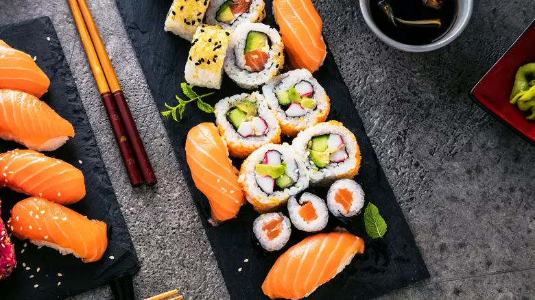 Sushi na czarnym łupku i szarym betonowym blacie