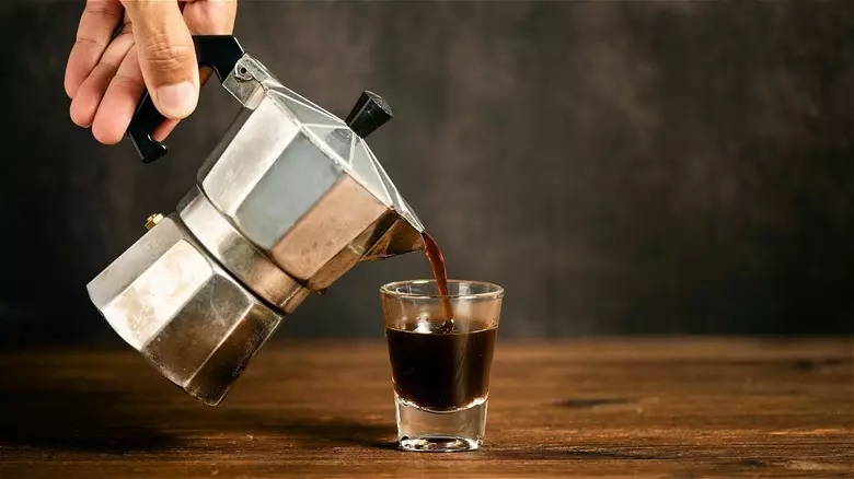 Eine Hand gießt Kaffee aus einer Mokkakanne