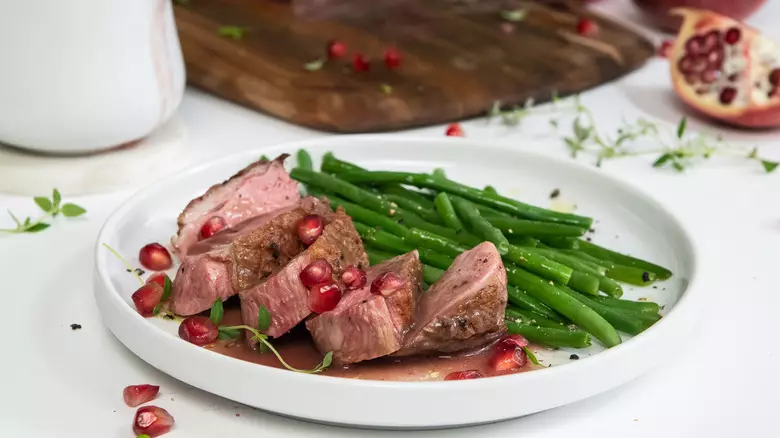 plato de pato con salsa de granada y verduras