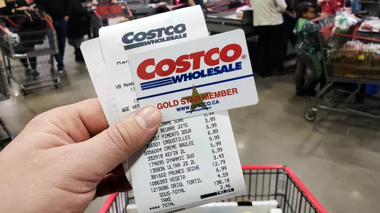 Tangan memegang kad dan resit Costco