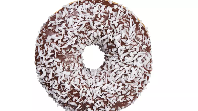 Donut de chocolate con coco sobre fondo branco
