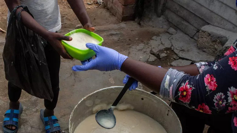 Omo Afirika gbigba ekan ti porridge