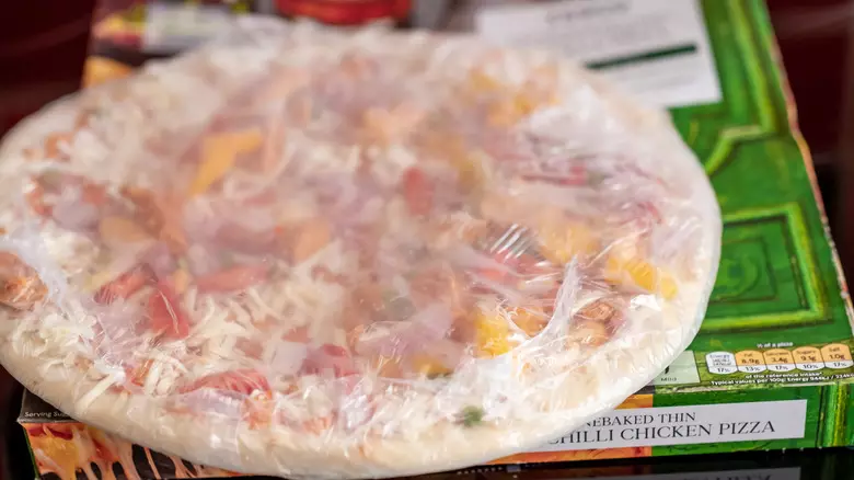 ボックスの上にラップで冷凍ピザ