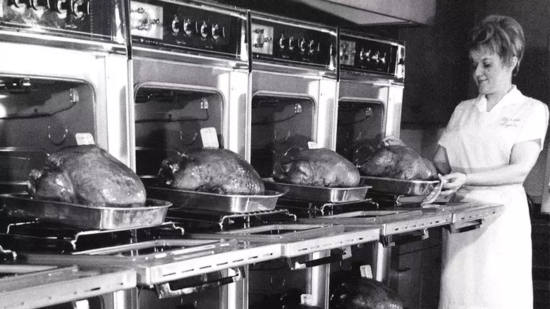 Ifoto emnyama nemhlophe yowesifazane ecaleni kwee-turkeys kwii-ovens