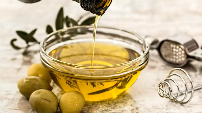 pouring olive oalje yn glêzen kom