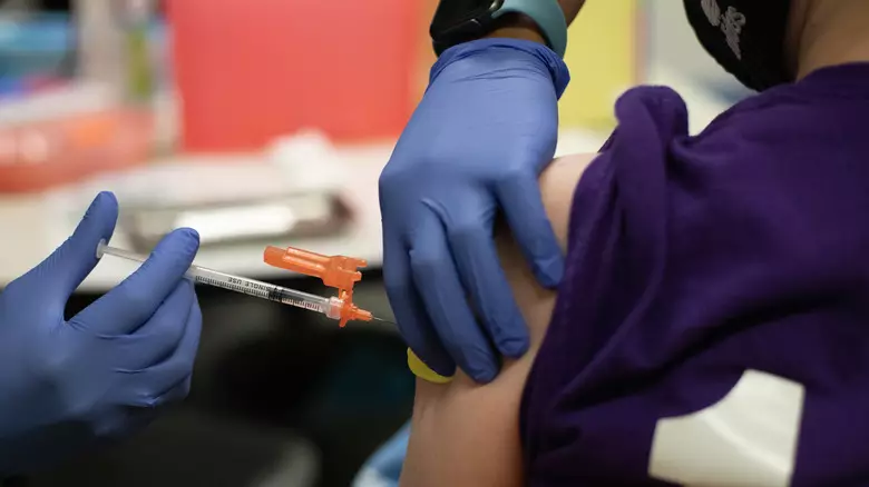 Jovem recebe vacina contra Covid-19
