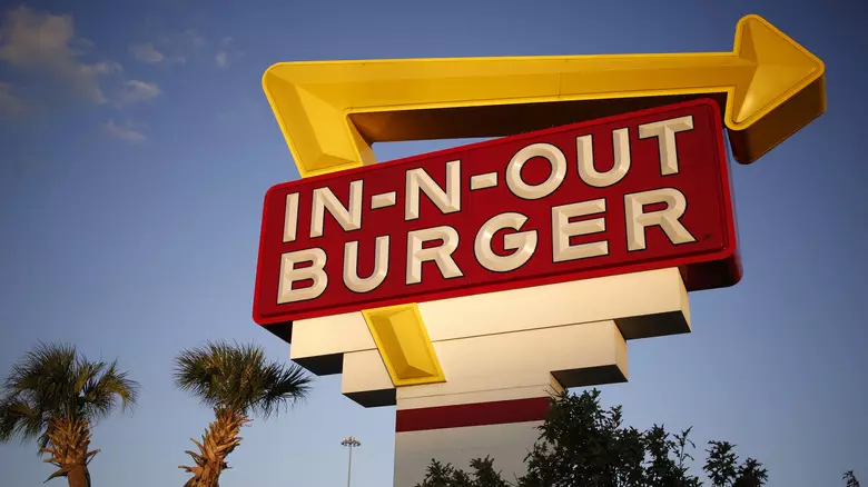 Een In-N-Out verkeersbord met palmbomen en blauwe lucht op de achtergrond