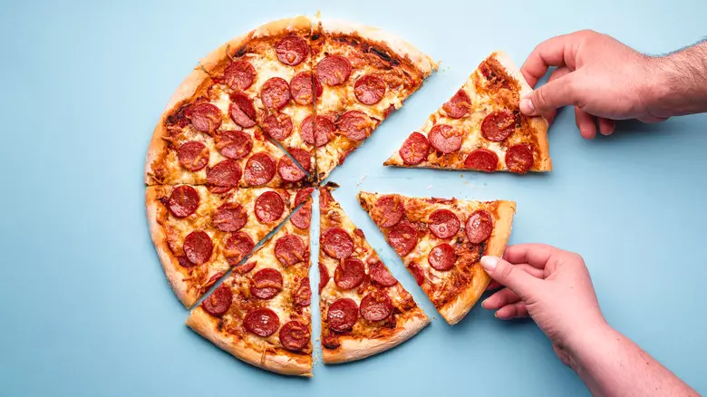 Tangan menyambar hirisan piza pepperoni