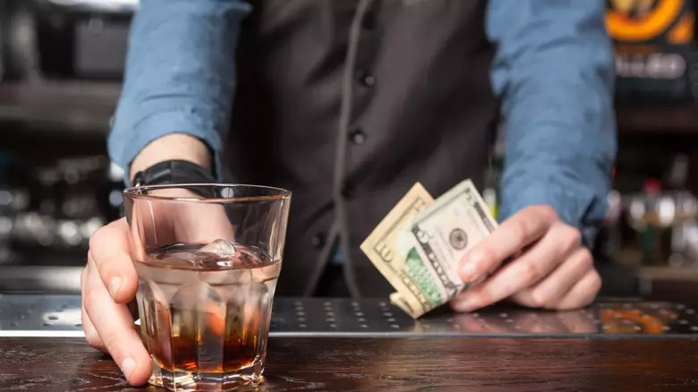 Wedang ing bar karo bartender njupuk tip