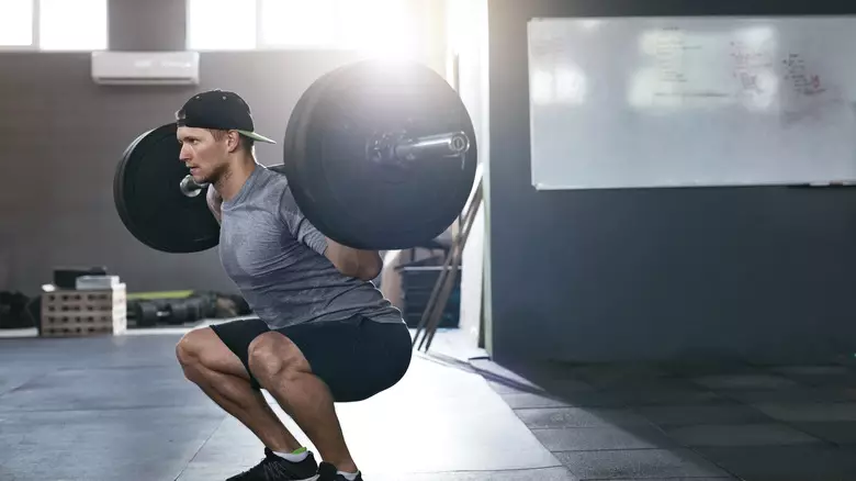 Vægtløfter laver squats i fitnesscenteret