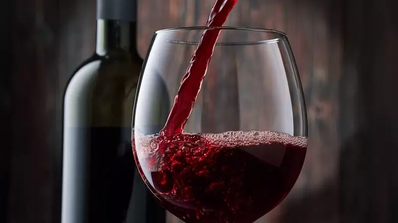 Rotwein wird in ein Glas gegossen