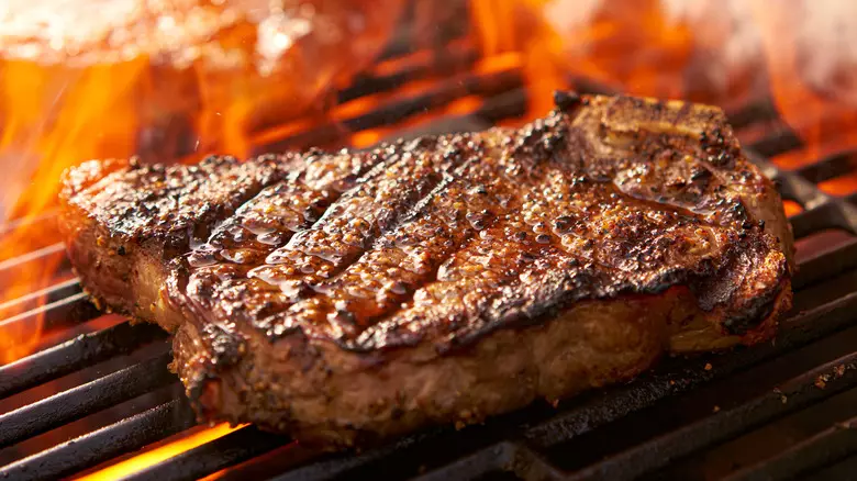 Ribeye steak op flaming grill