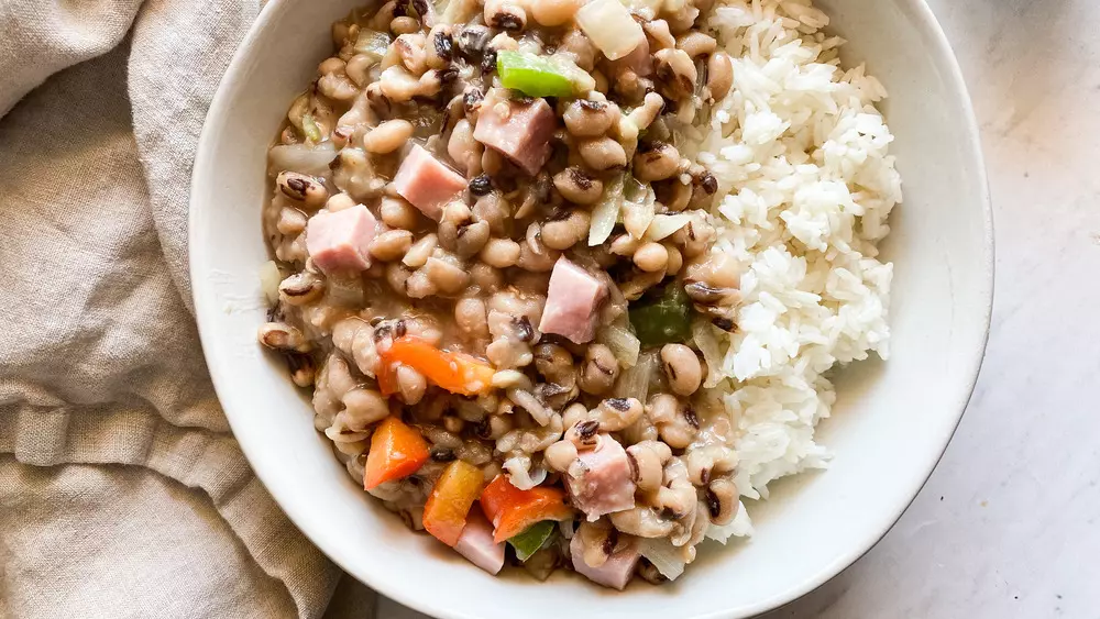 Hoppin John em uma tigela branca com arroz e presunto