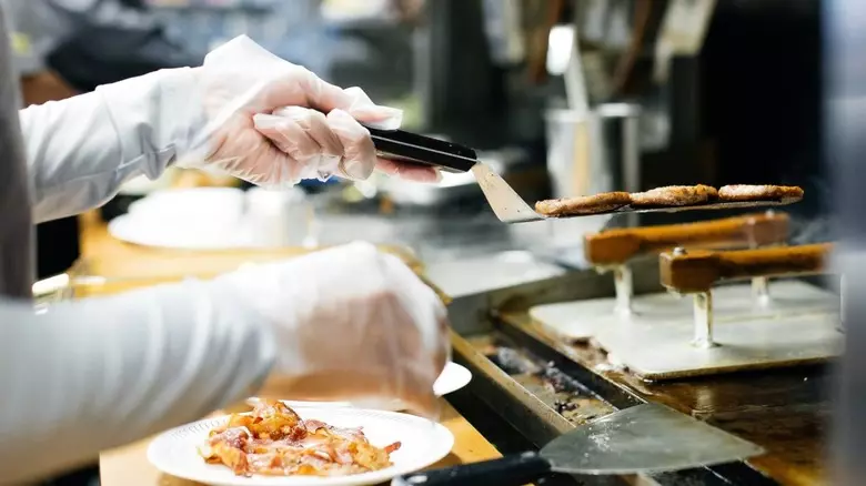 Un empleado de Waffle House manejando una parrilla