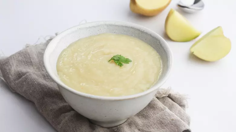 bol de sopa de patates al costat de la patata i la cullera