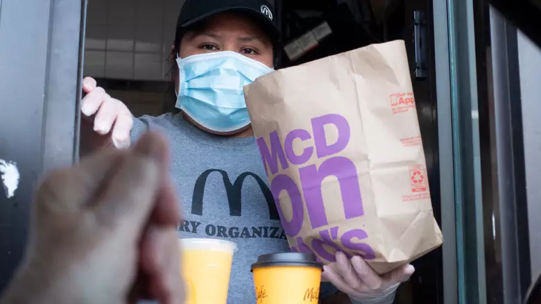 Pracownik McDonald's trzymający torbę w drive-thru