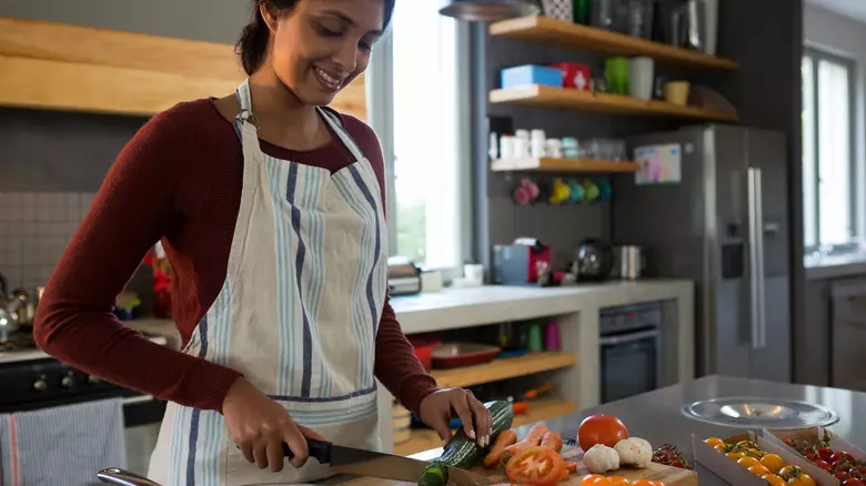 un chef de casa cortando verduras