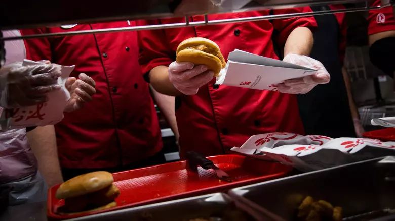 Chick-fil-A-werkers wat hamburgers opstop