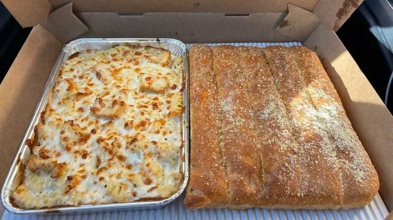 O tavă cu paste cremoase Alfredo și grisine de la Pizza Hut.