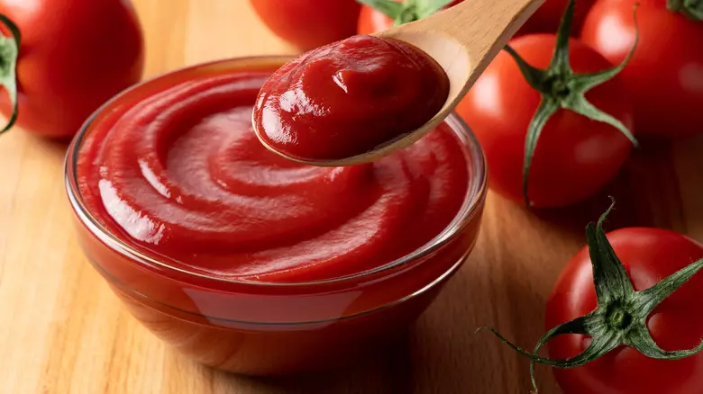 skål ketchup med tomater i baggrunden