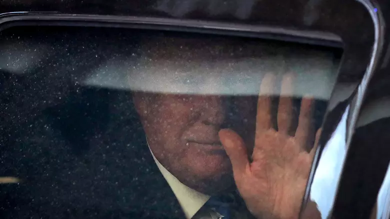 Ο Ντόναλντ Τραμπ ως Πρόεδρος που κυματίζει πίσω από ένα γυάλινο παράθυρο μιας λιμουζίνας