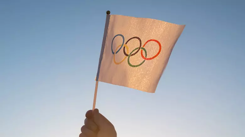 Πρόσωπο που κυματίζει Ολυμπιακή σημαία