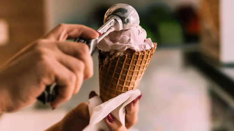 Mão pegando sorvete no cone