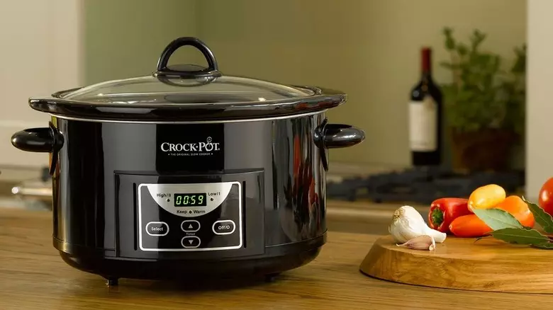 slowcooker met bottel wyn in agtergrond