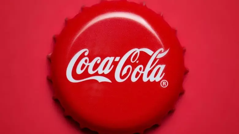 Tutup botol Coca-cola dina latar beureum