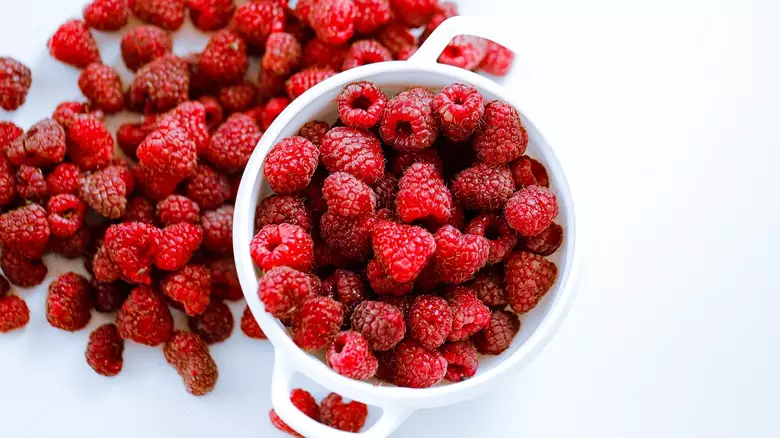 Himbeeren in Schüssel und Verschütten